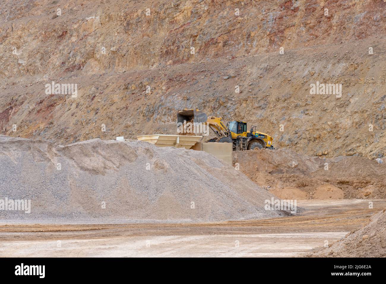 A front-end loader dumping gravel in a hopper for screening at an ...