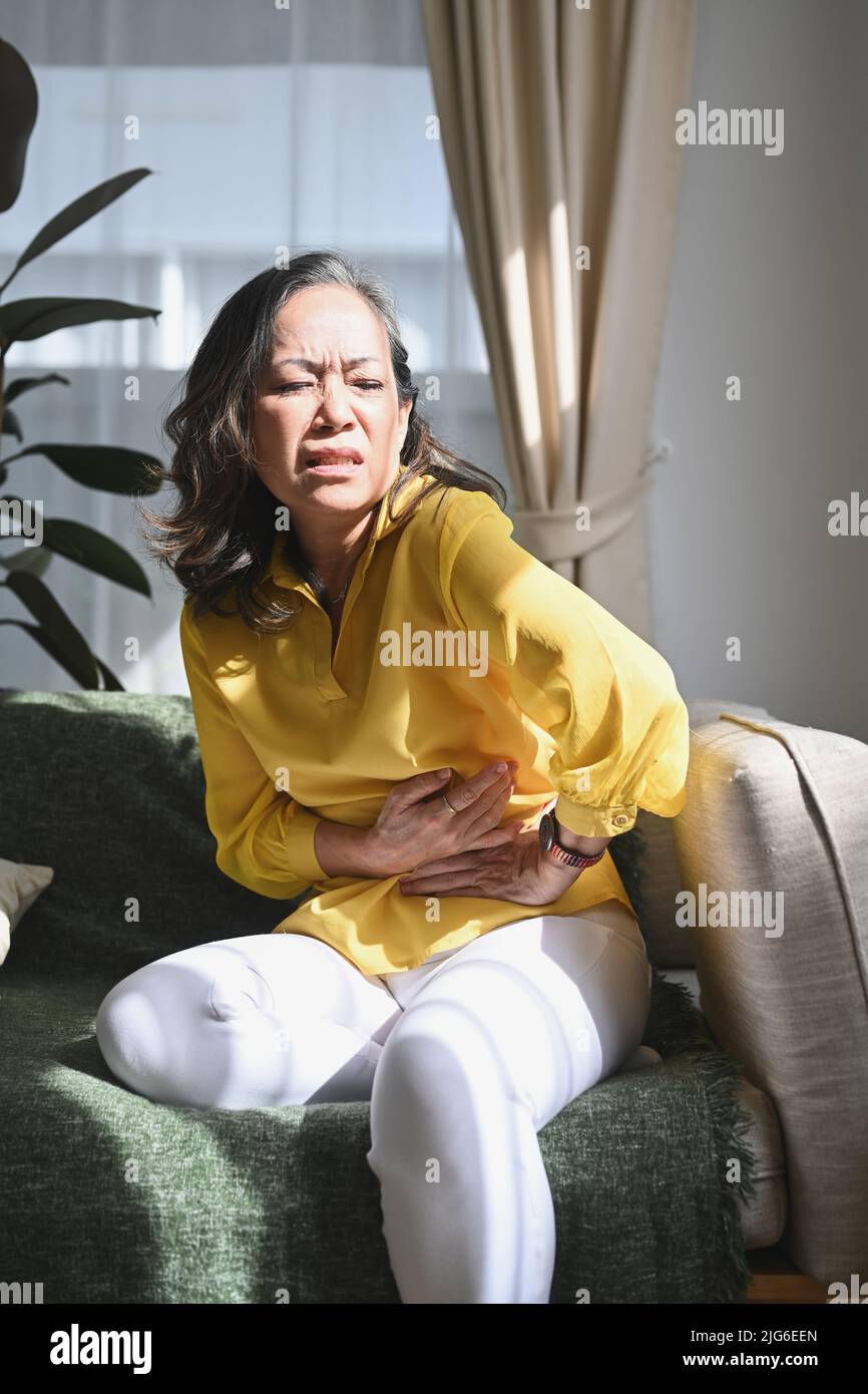 Upset mature woman suffering from abdomen ache, symptoms ...