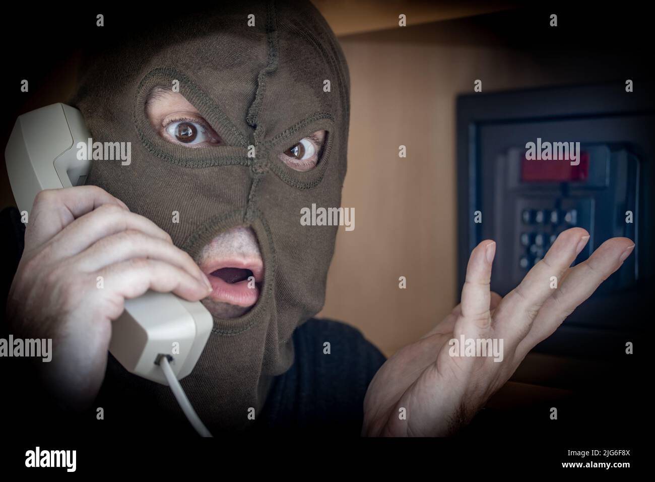 A man in a mask calls assistance service for help with opening a locked ...