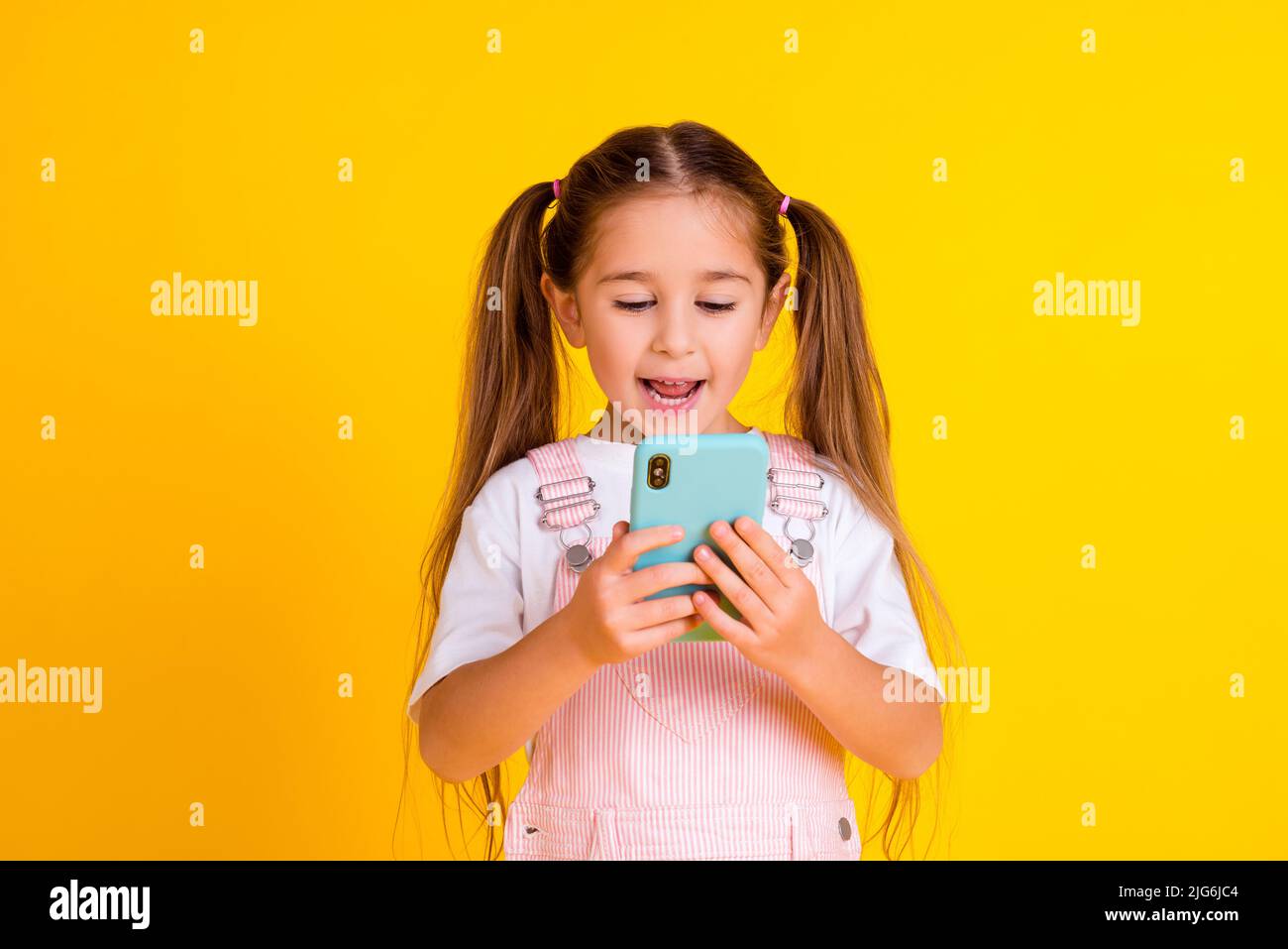 Photo of sweet charming school girl wear summer overall reading modern ...