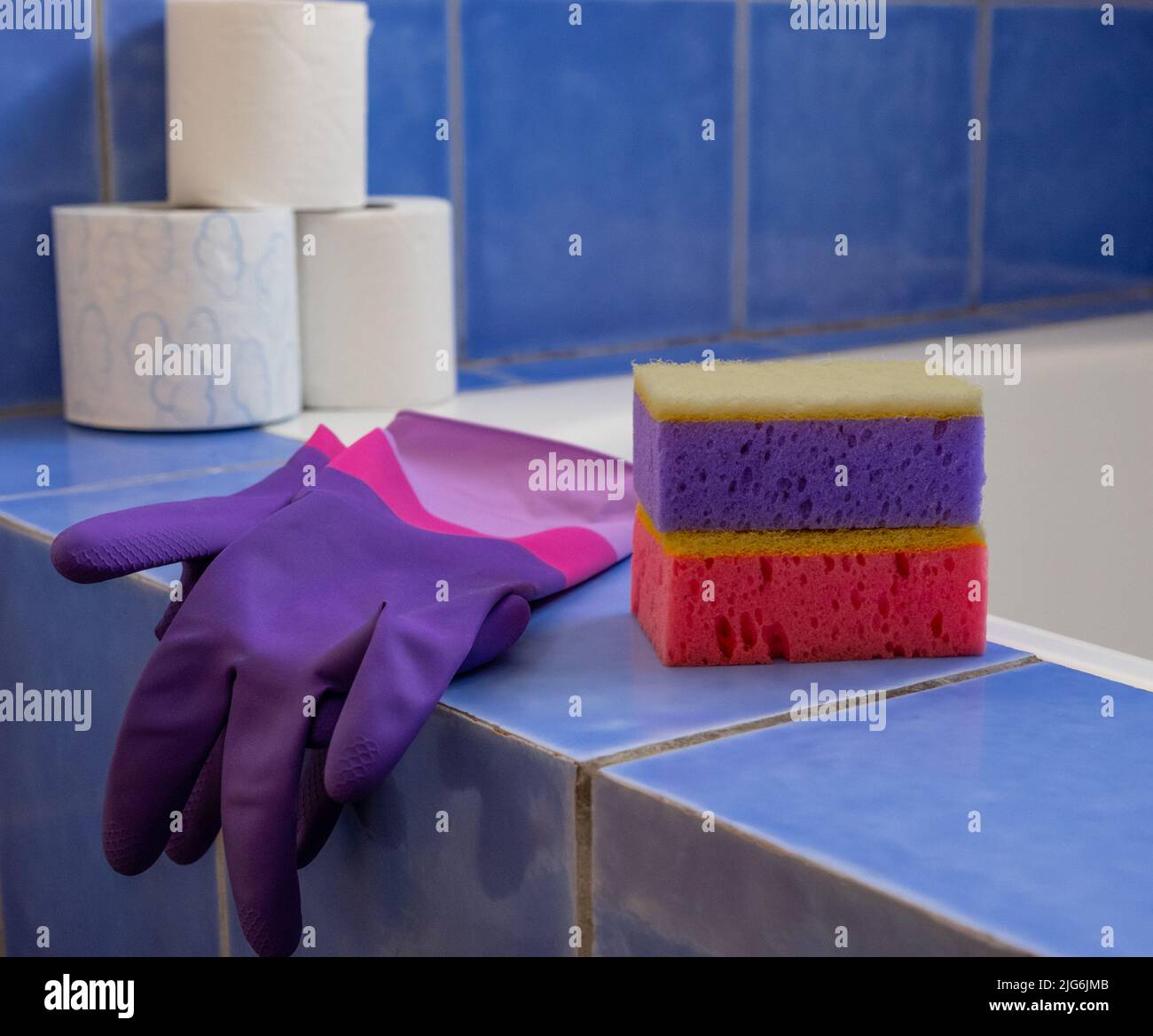 Rubber gloves and sponges inside bathroom. Closeup. Set of colorful accessory for house cleaning ...