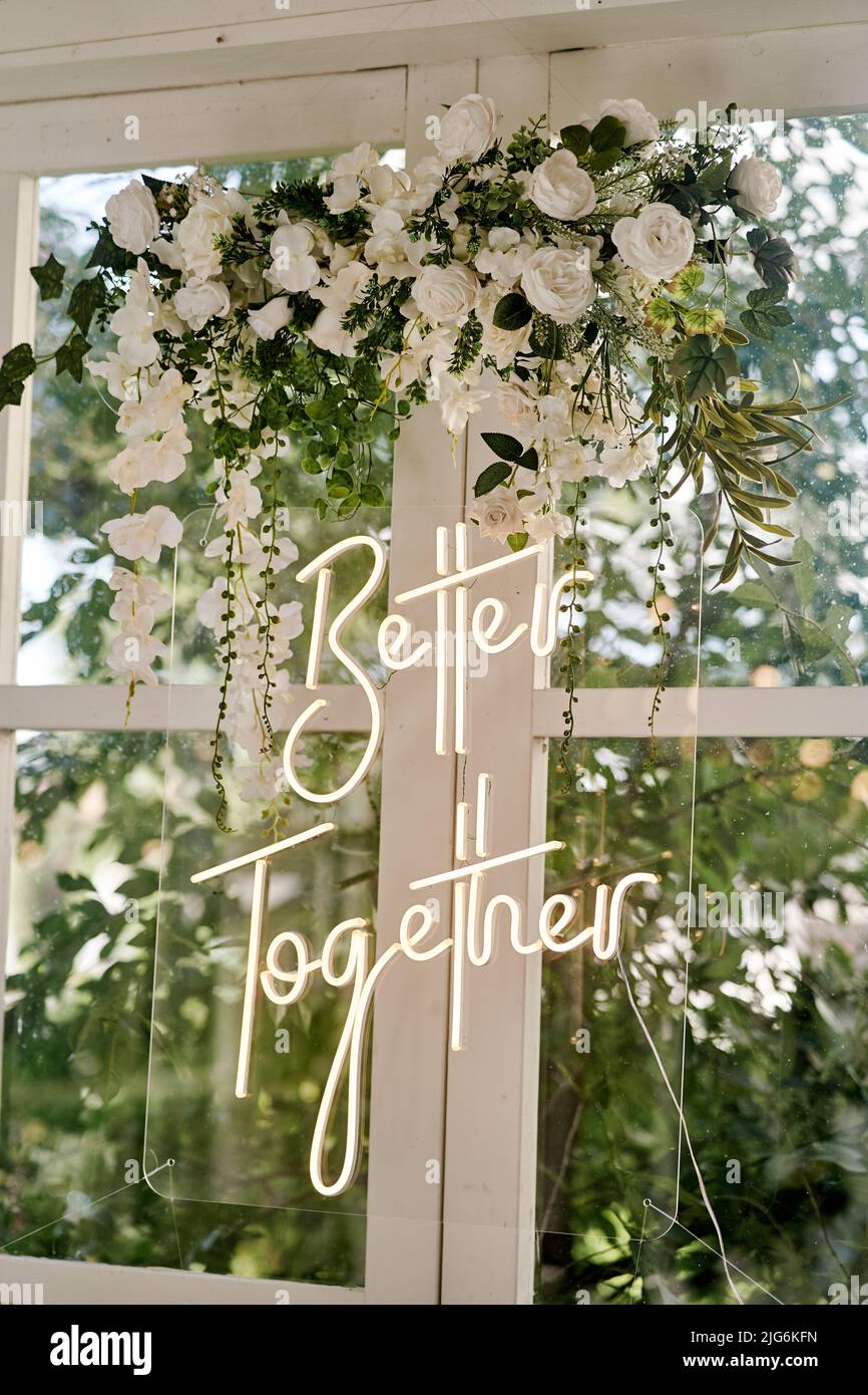 Better Together - neon sign on a window with white flowers at a wedding ...