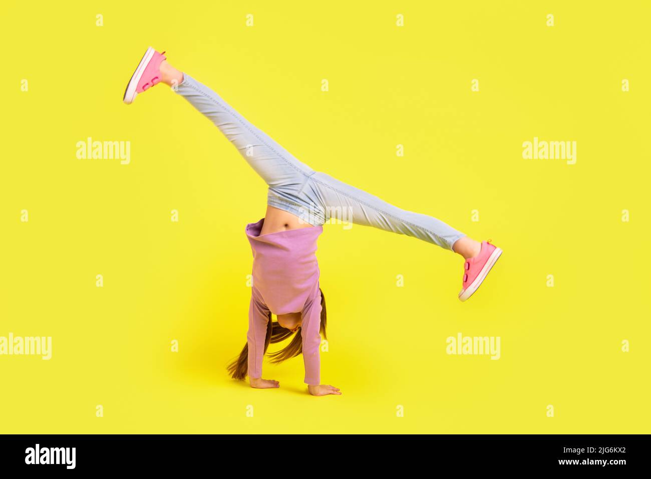 Photo of school child stand on hands doing acrobat practice isolated ...
