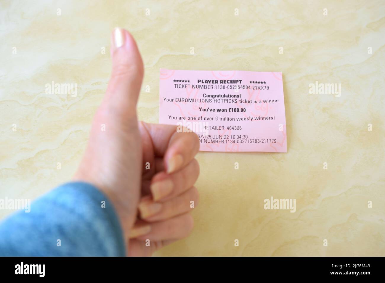 Thumb up with winning Euromillion lottery slip and British money Stock ...