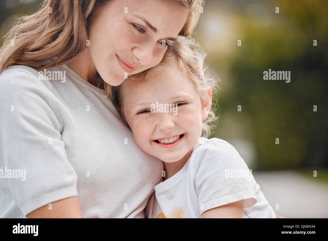 Closeup of loving caucasian mother giving her adorable daughter a hug ...
