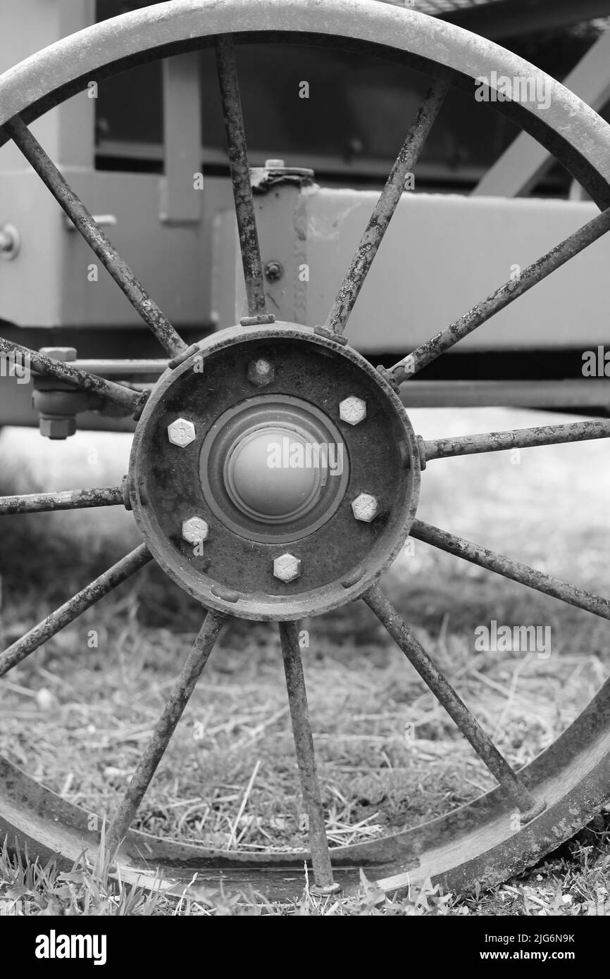 A vintage metal tractor wheel with an axle and exposed spokes Stock ...