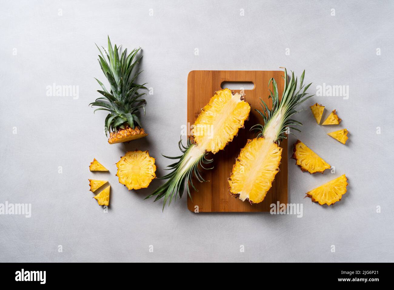Top view of fresh cut pineapple with tropical leaves on dark blue ...