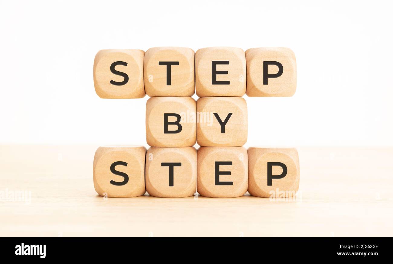 Step by Step message on wooden block shape Stock Photo - Alamy