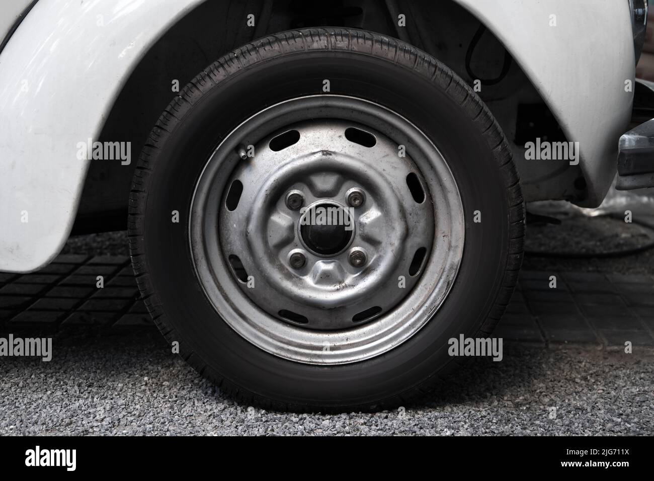 Close-up photo of a wheel of a white old car parked on a road Stock ...