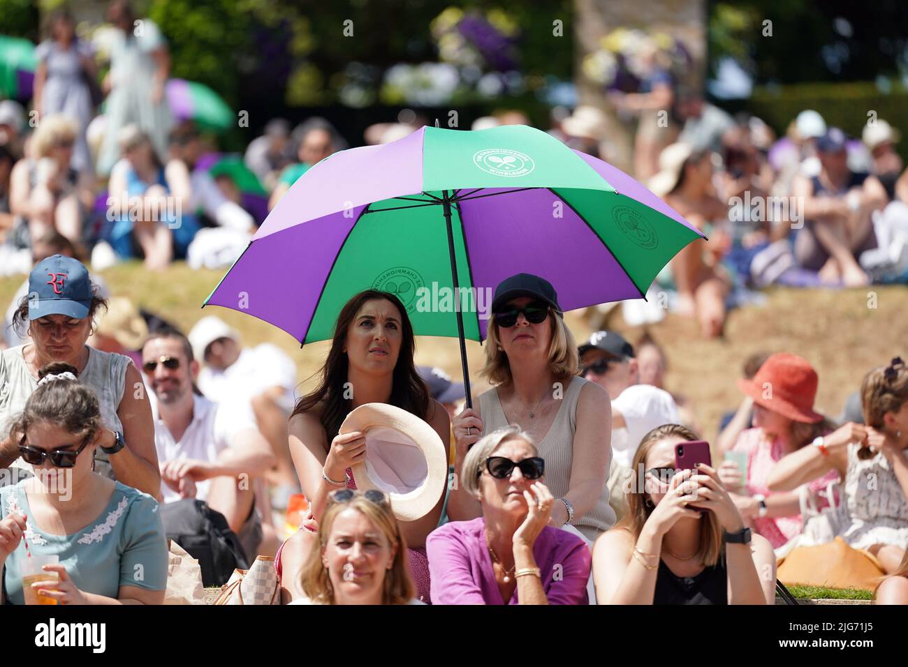 Spectators shield from the sun on day twelve of the 2022 Wimbledon ...