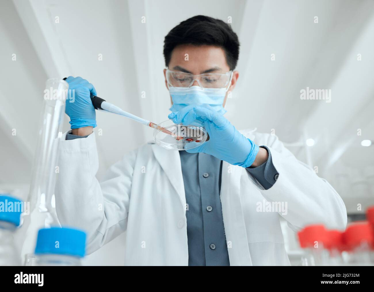 Slow and steady wins the race. Shot of a young male scientist inserting ...