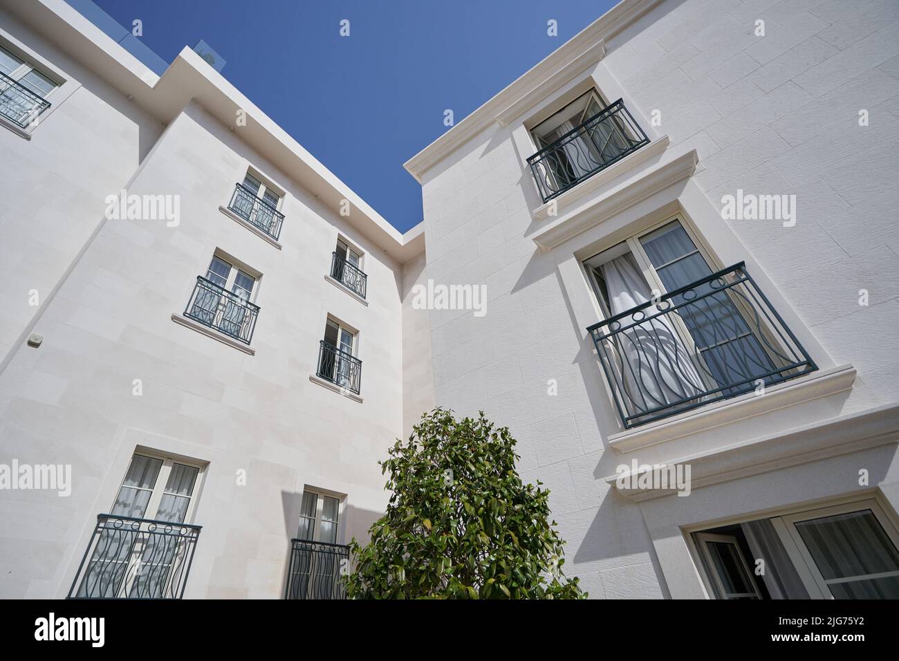 Beige apartment building and beige high windows Stock Photo - Alamy