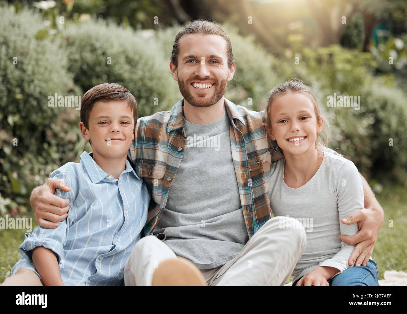 Smile for the camera. Shot of a father posing with his children outside ...