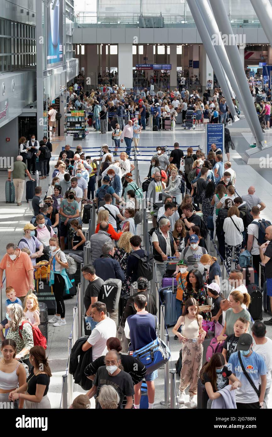 Passengers waiting for check-in in front of the check-in counter, queue ...