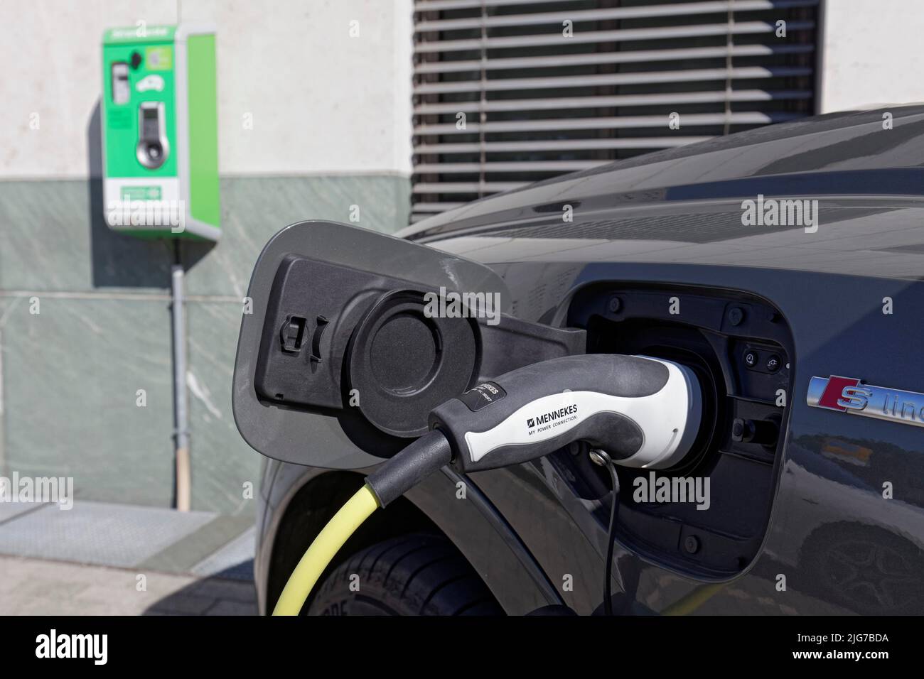 Electric car being charged, charging station in front of a company ...