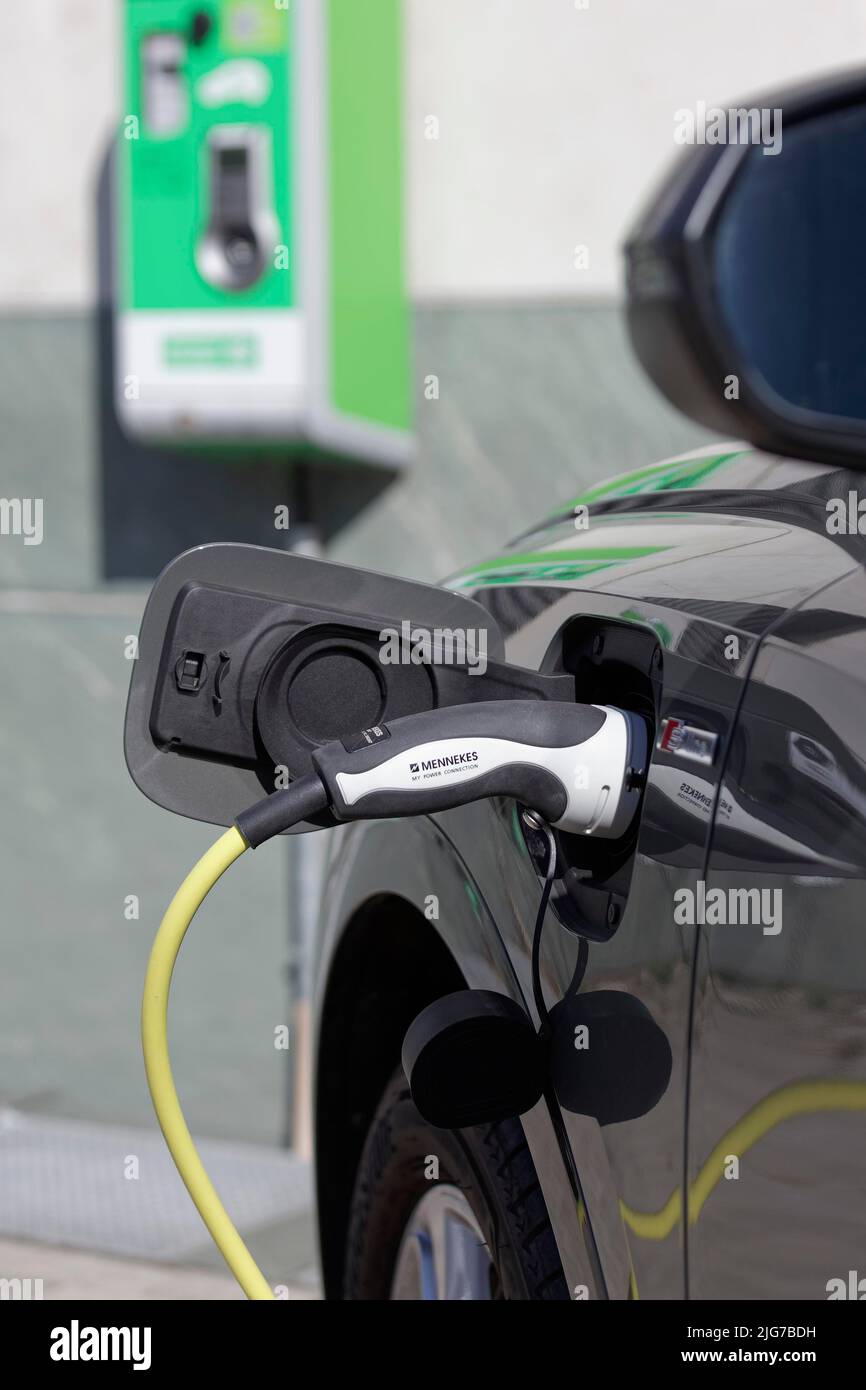 Electric car being charged, charging station in front of a company ...