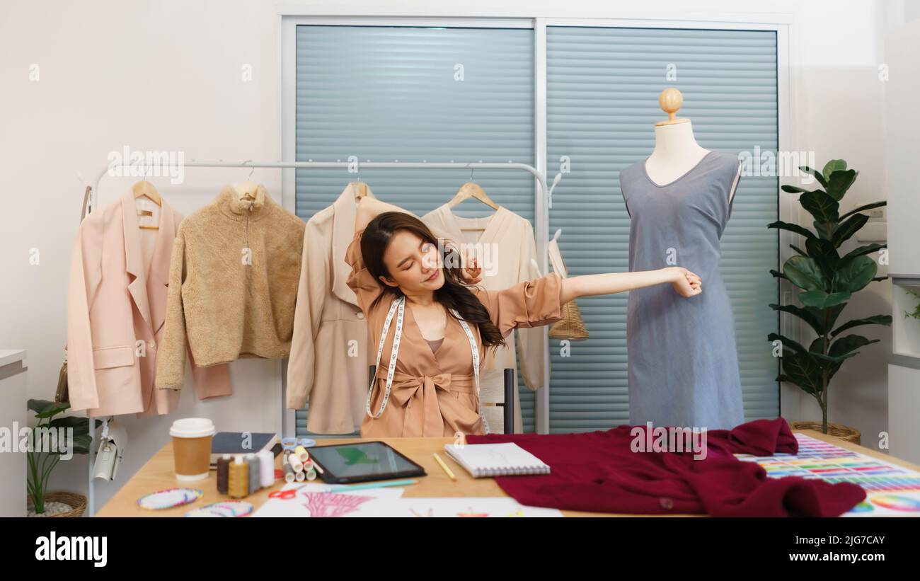 Fashion design concept, Asian female designer stretching to relax after ...