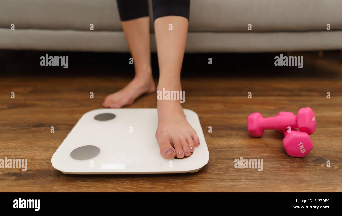 Healthy and weight loss concept, Young Asian woman stepping on weighing ...