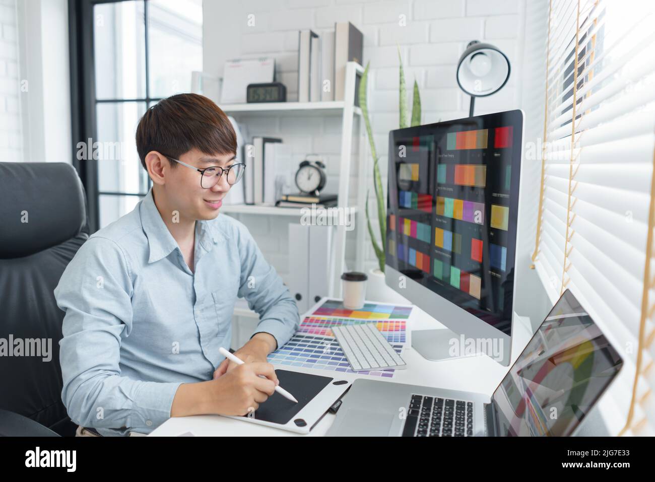 Creativity concept, Male graphic designer using tablet and looking ...