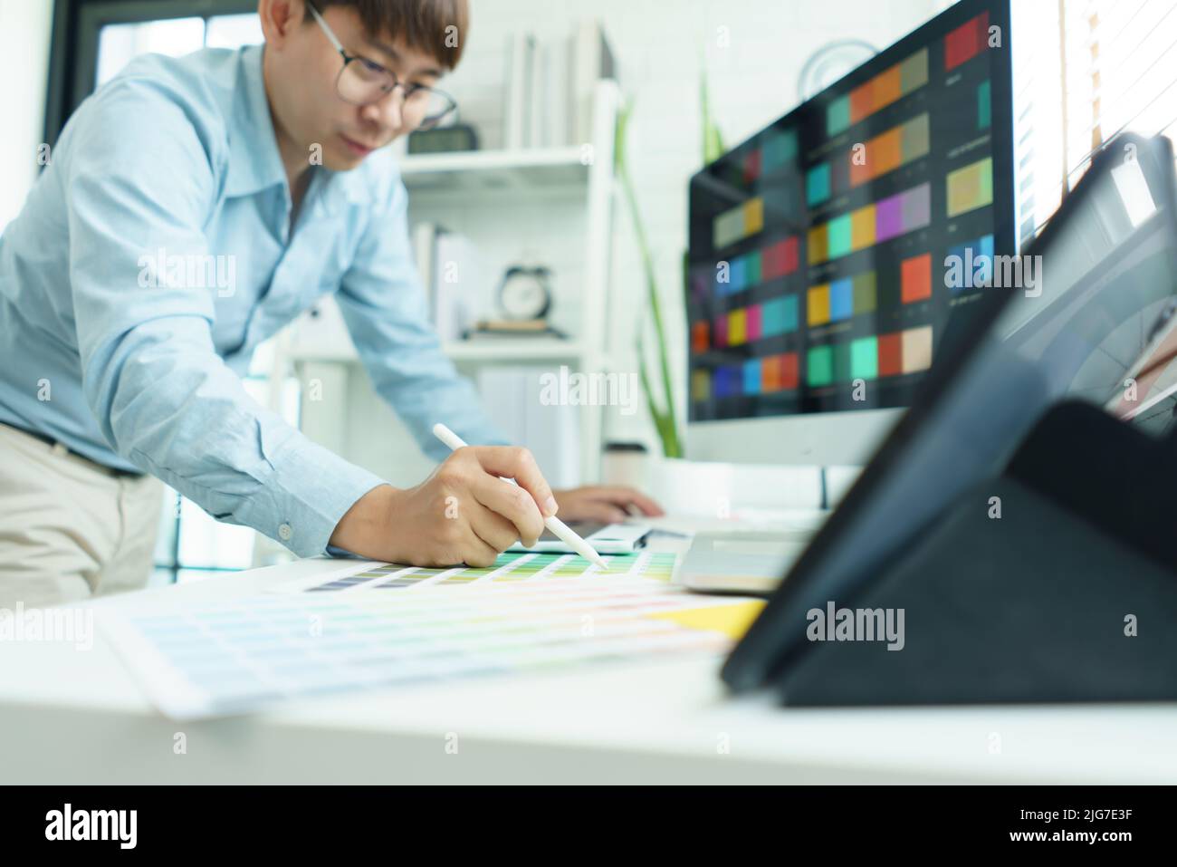 Creativity concept, Male graphic designer choosing color swatch samples ...