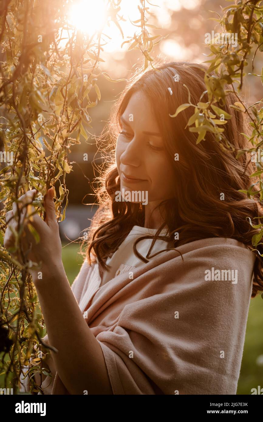 Beautiful romantic woman enjoying spring nature at sunset. Close-up ...