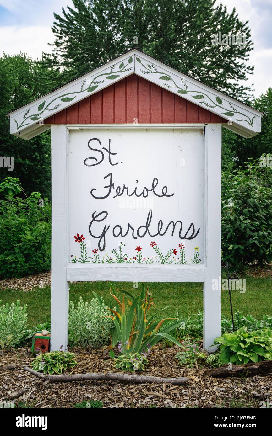 A white sign painted in cursive, "St. Feriole Gardens", in black paint ...