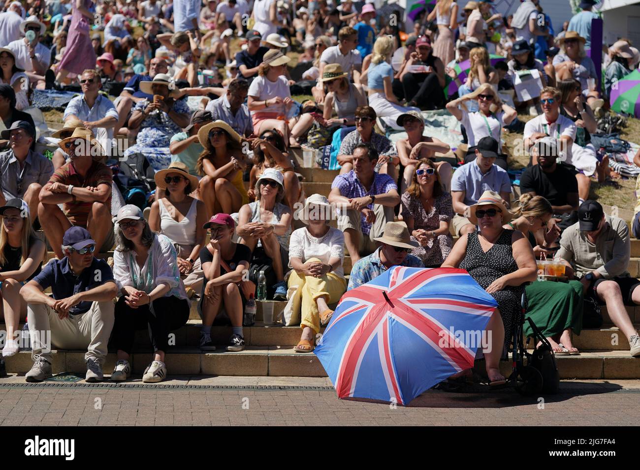 Spectators shield from the sun on day twelve of the 2022 Wimbledon ...