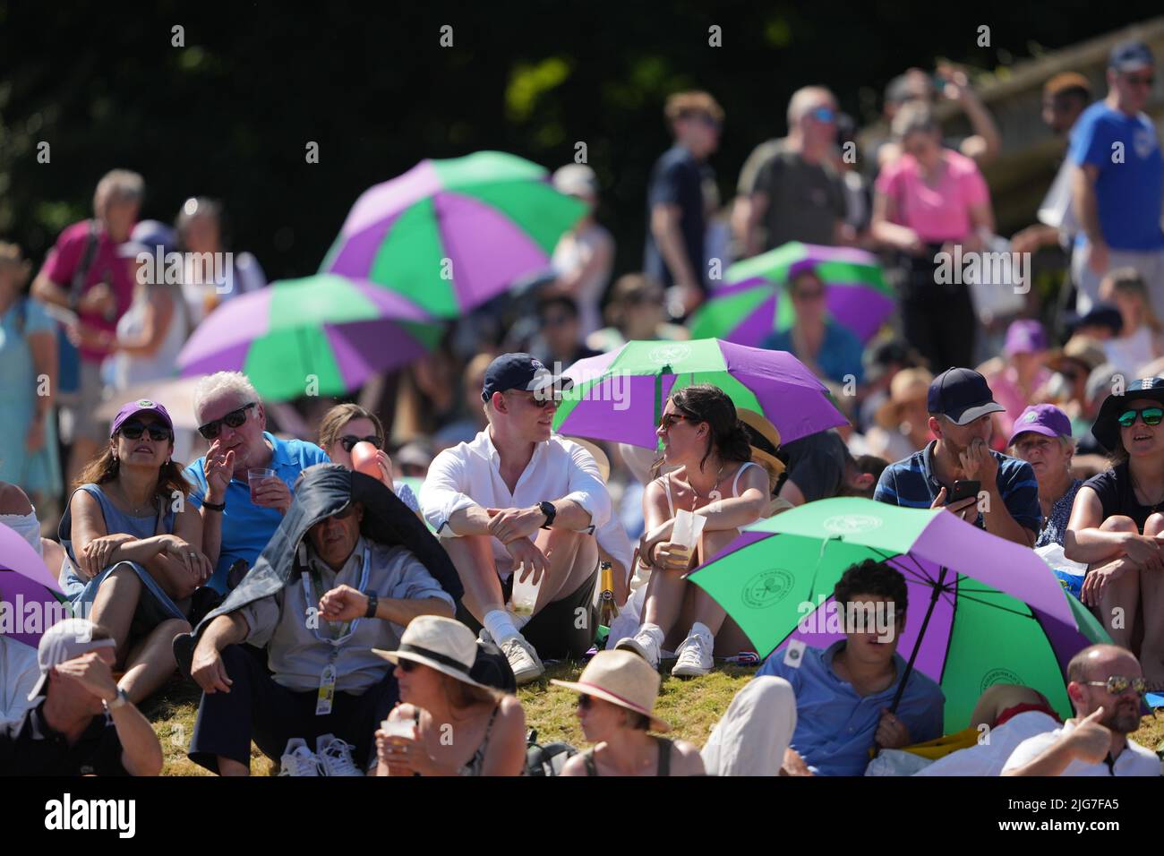 Spectators shield from the sun on day twelve of the 2022 Wimbledon ...