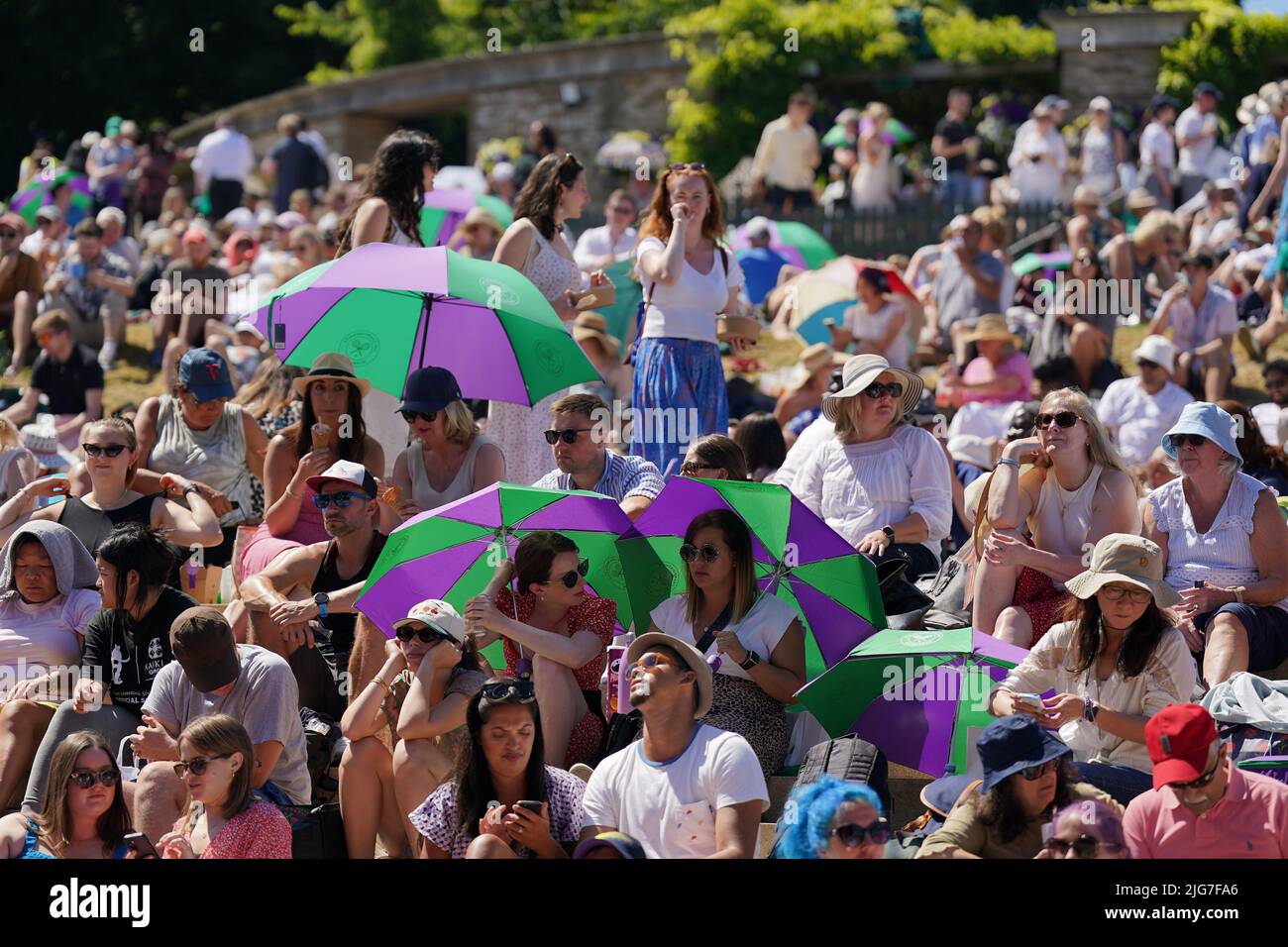 Spectators shield from the sun on day twelve of the 2022 Wimbledon ...