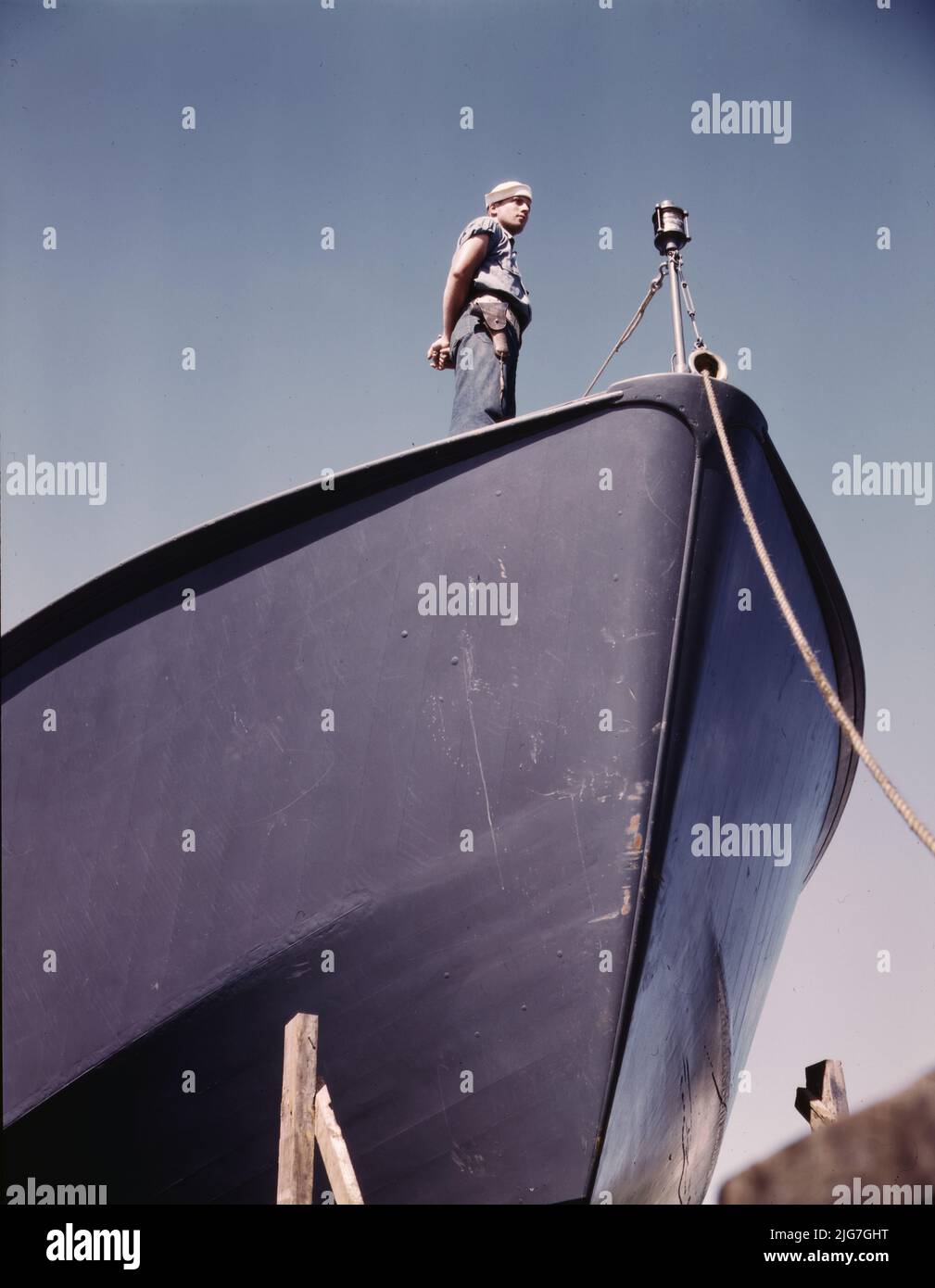 A Coast Guard sentry stands watch over a new torpedo boat under ...