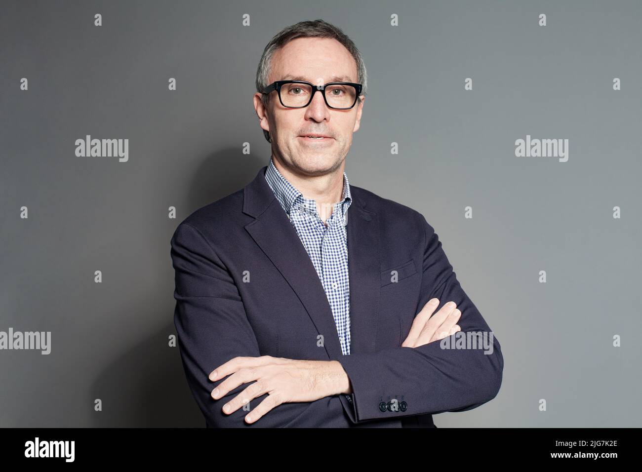 Smart friendly professional man wearing glasses on grey background ...