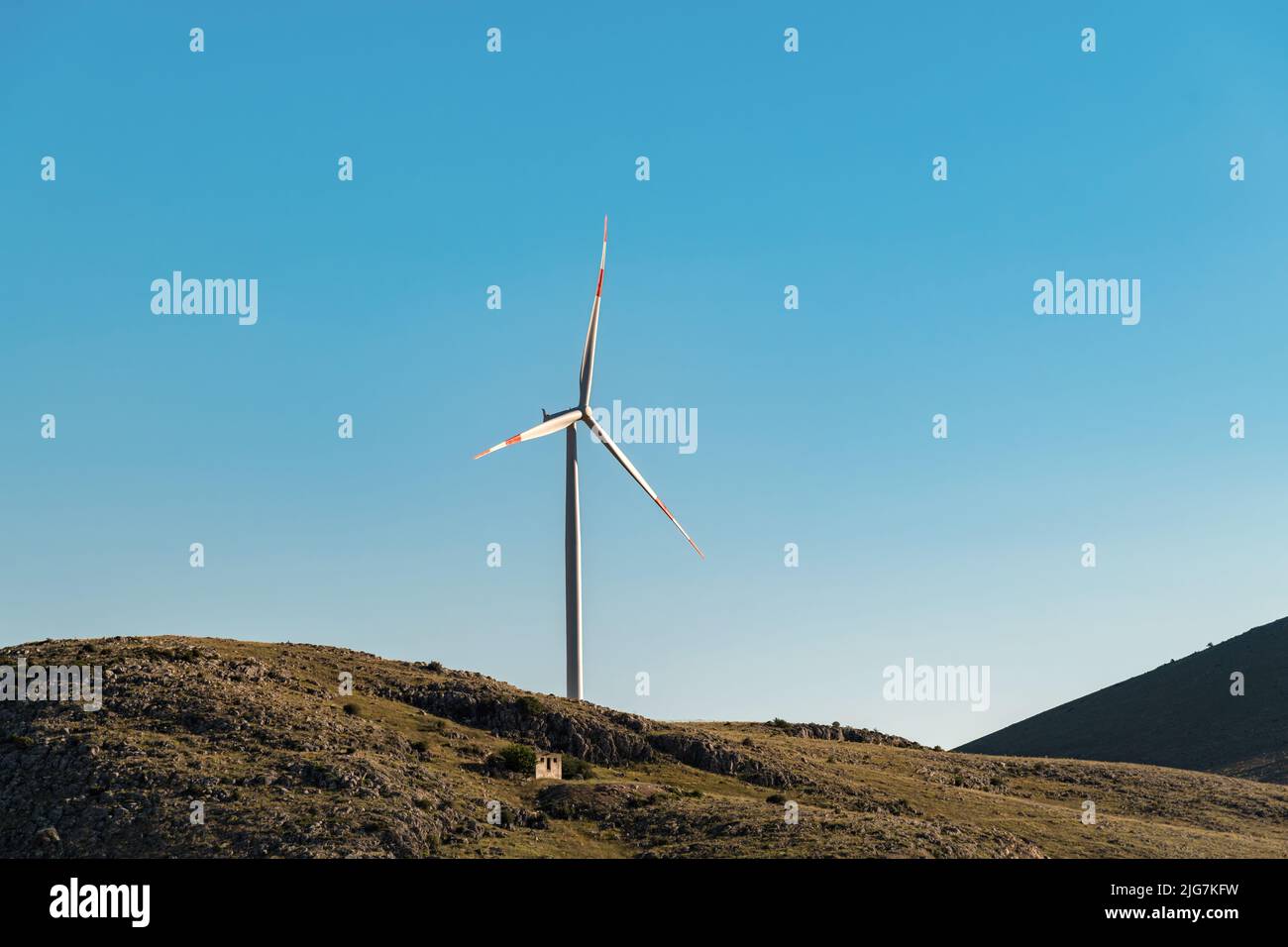 clean electricity producing wind turbine or windmill built on a windy ...