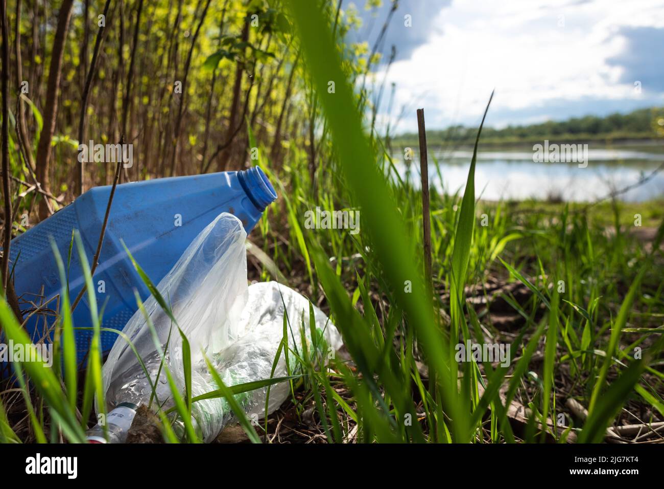 Abandoned garbage plastic and glass waste in nature among the grass ...