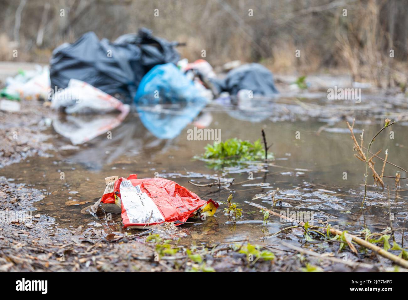 Abandoned garbage plastic and glass waste in nature among the grass ...