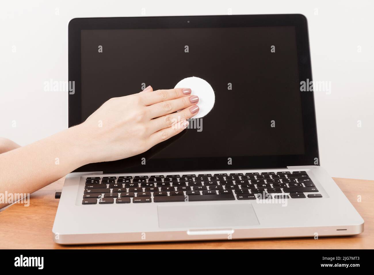 Woman hand wiping laptop screen with cotton ball Stock Photo - Alamy