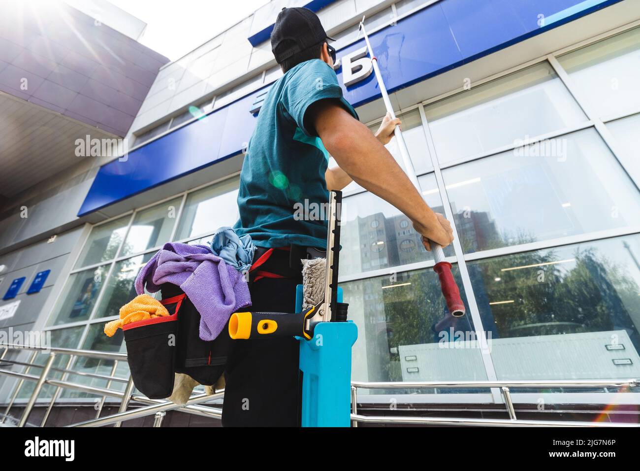 Male professional cleaning service worker in overalls cleans the ...