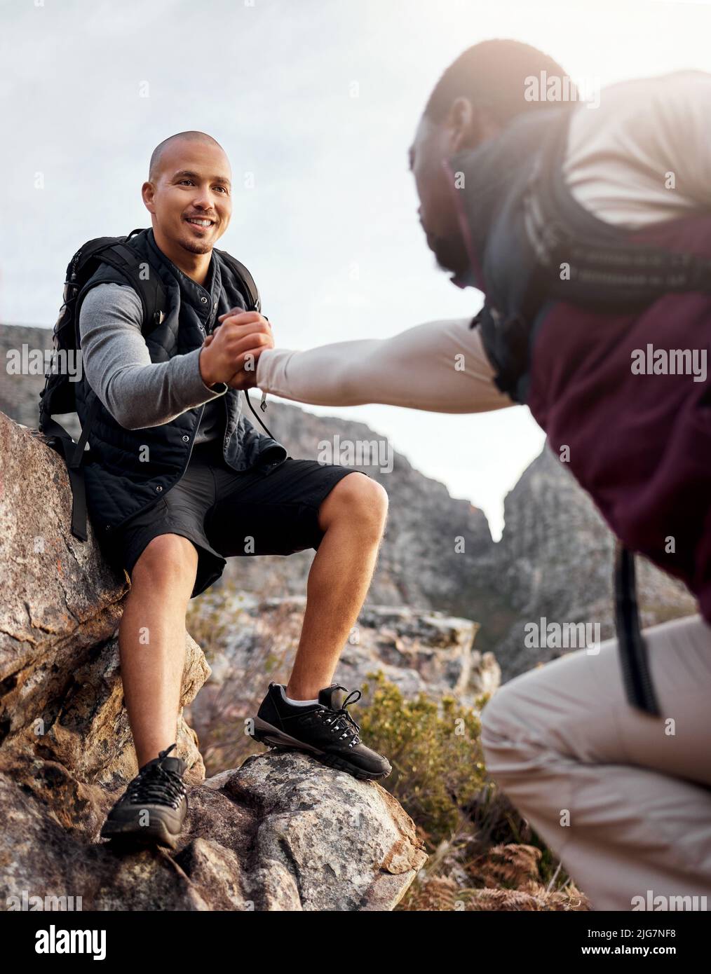 Lemme give you a hand. Cropped shot of a handsome young man helping his ...