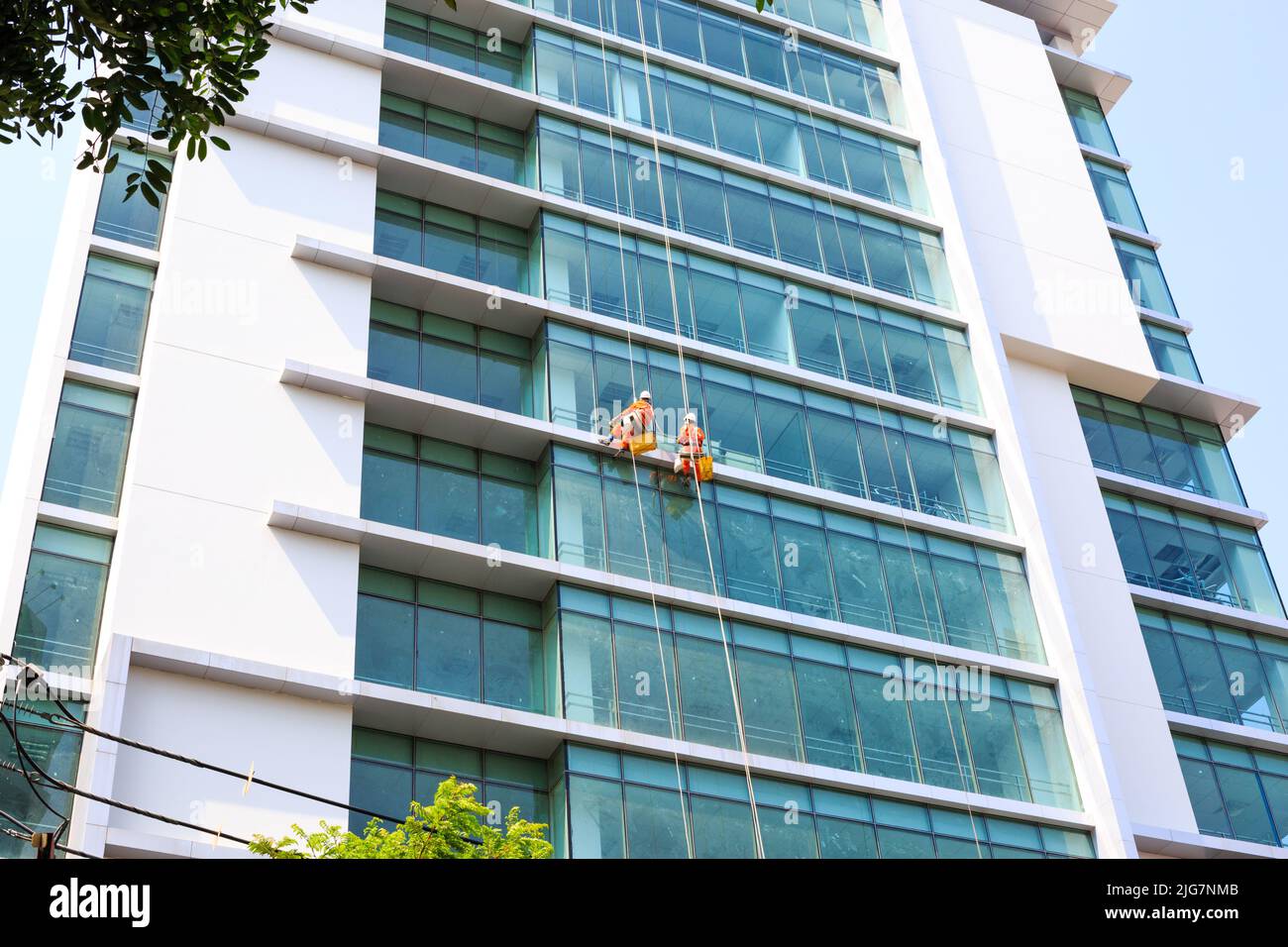 group of window washers hanging on ropes on a skyscraper facade Stock ...