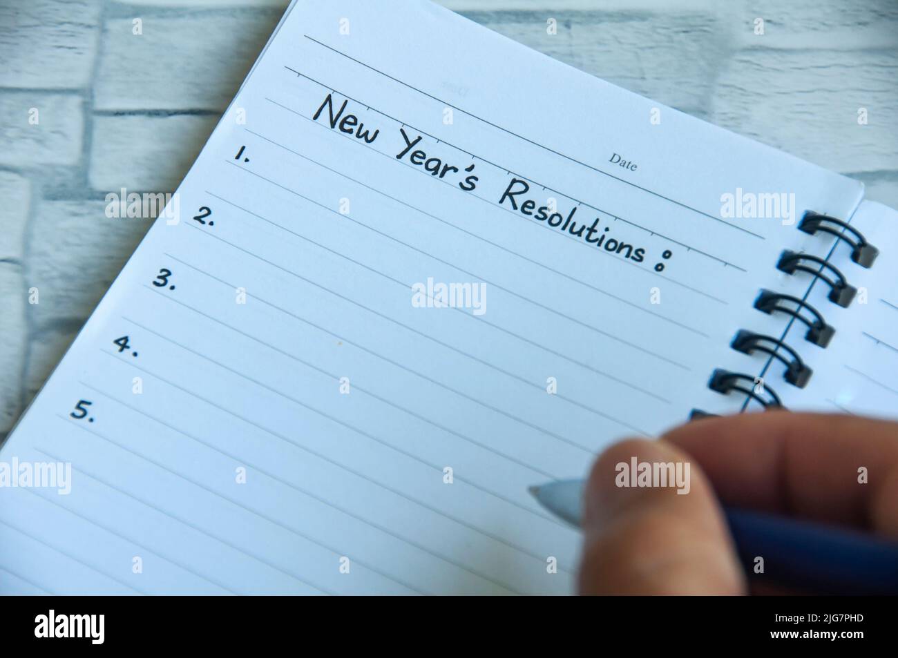 Hand writing New Year's Resolutions text on notepad. New year's ...