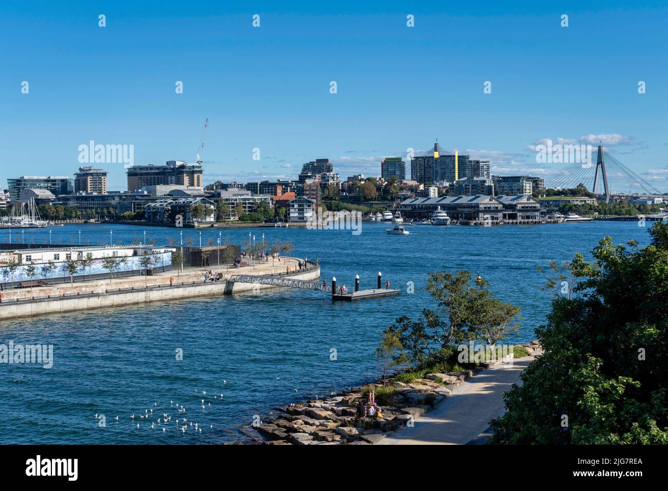 An aerial view of a harbor with Anzac Bridge in the background on a ...