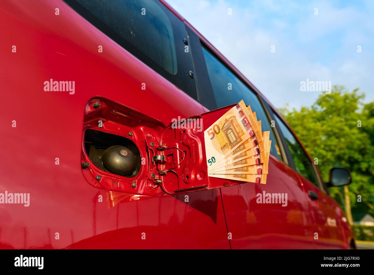 A bundle of fifty euro notes sticking out of a car's open fuel tank ...