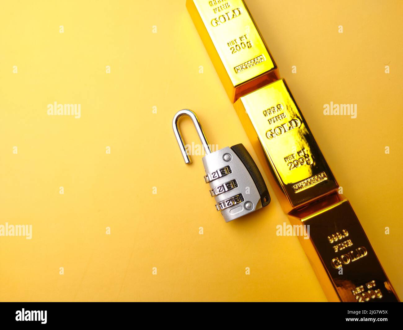 Three gold bars and a padlock isolated on a yellow background - finance ...