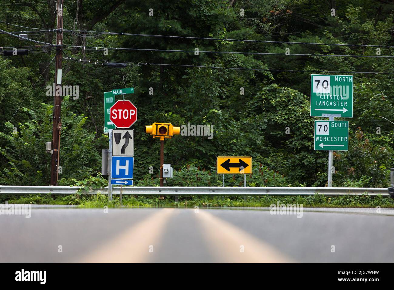 A low-angle shot of traffic signs and symbols on the side of a road ...