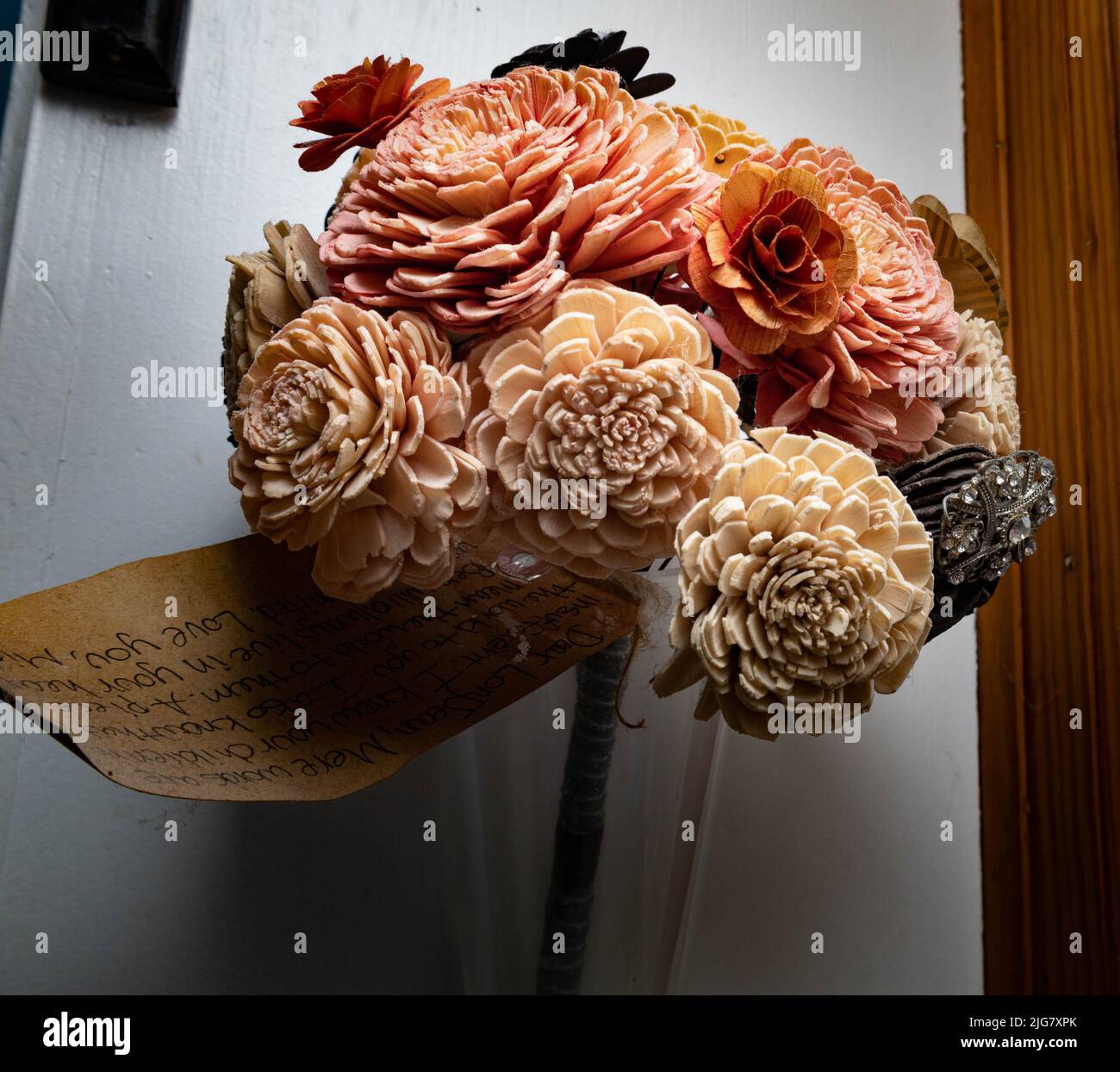 A closeup shot of a colorful flowers bouquet with paper note on blurry ...