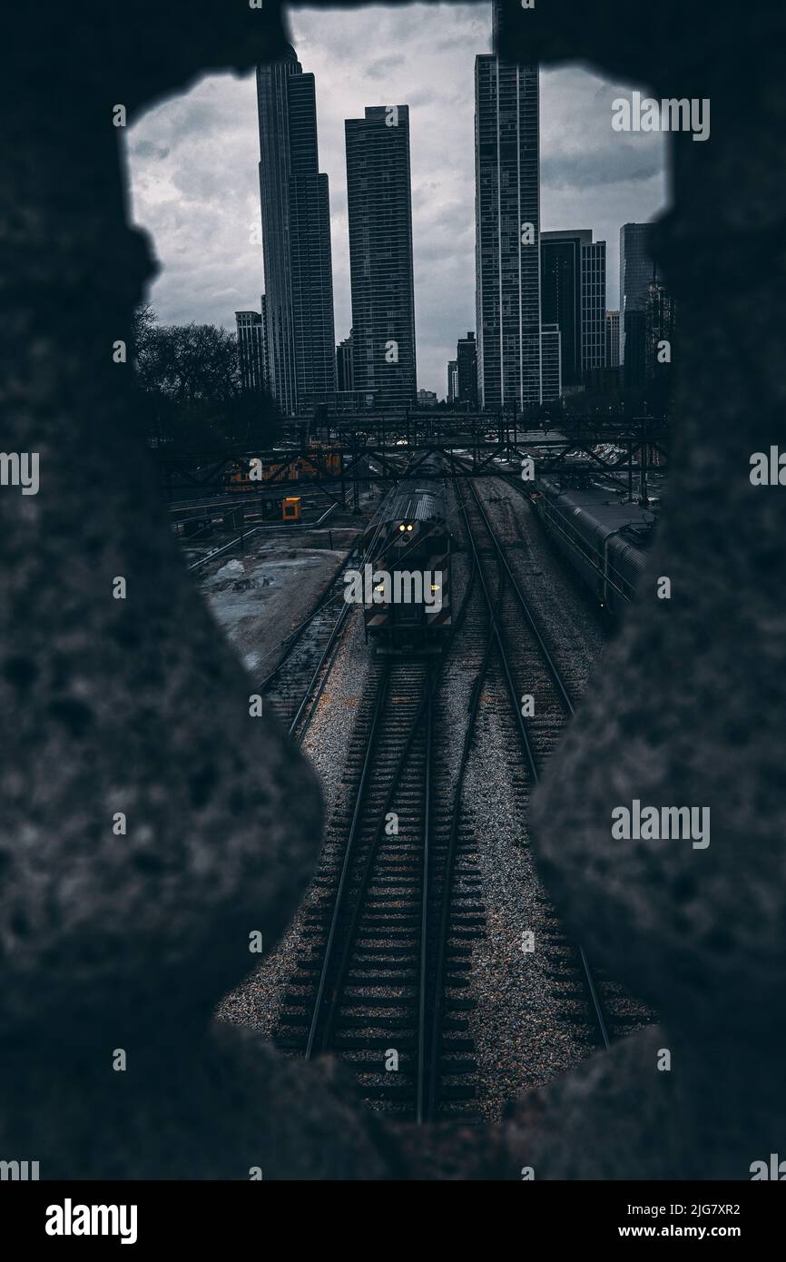 A view of the train on the railway through stone columns with ...