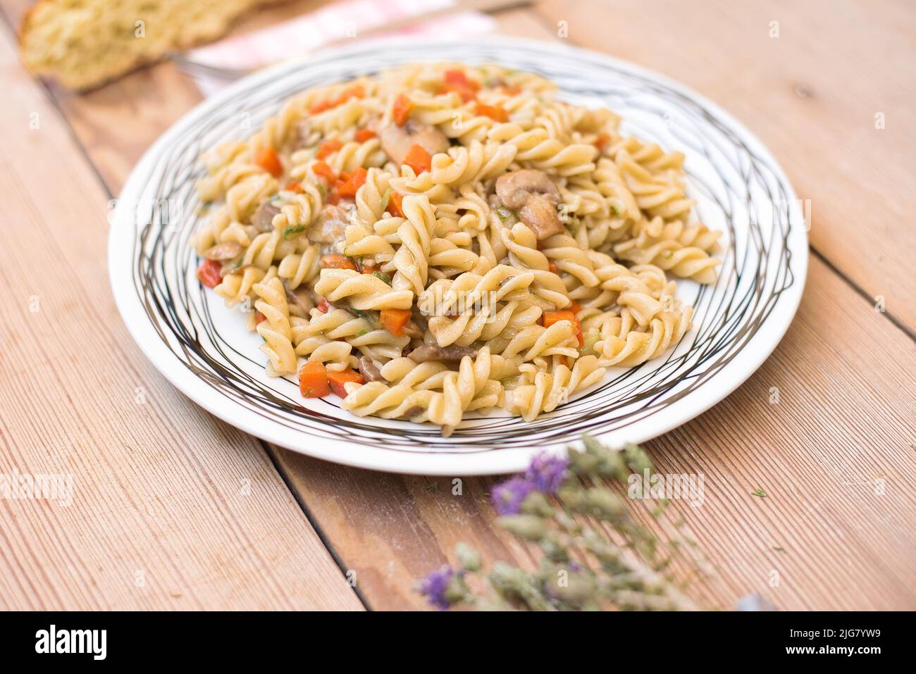 fusilli pasta on plate, on wooden table Stock Photo - Alamy