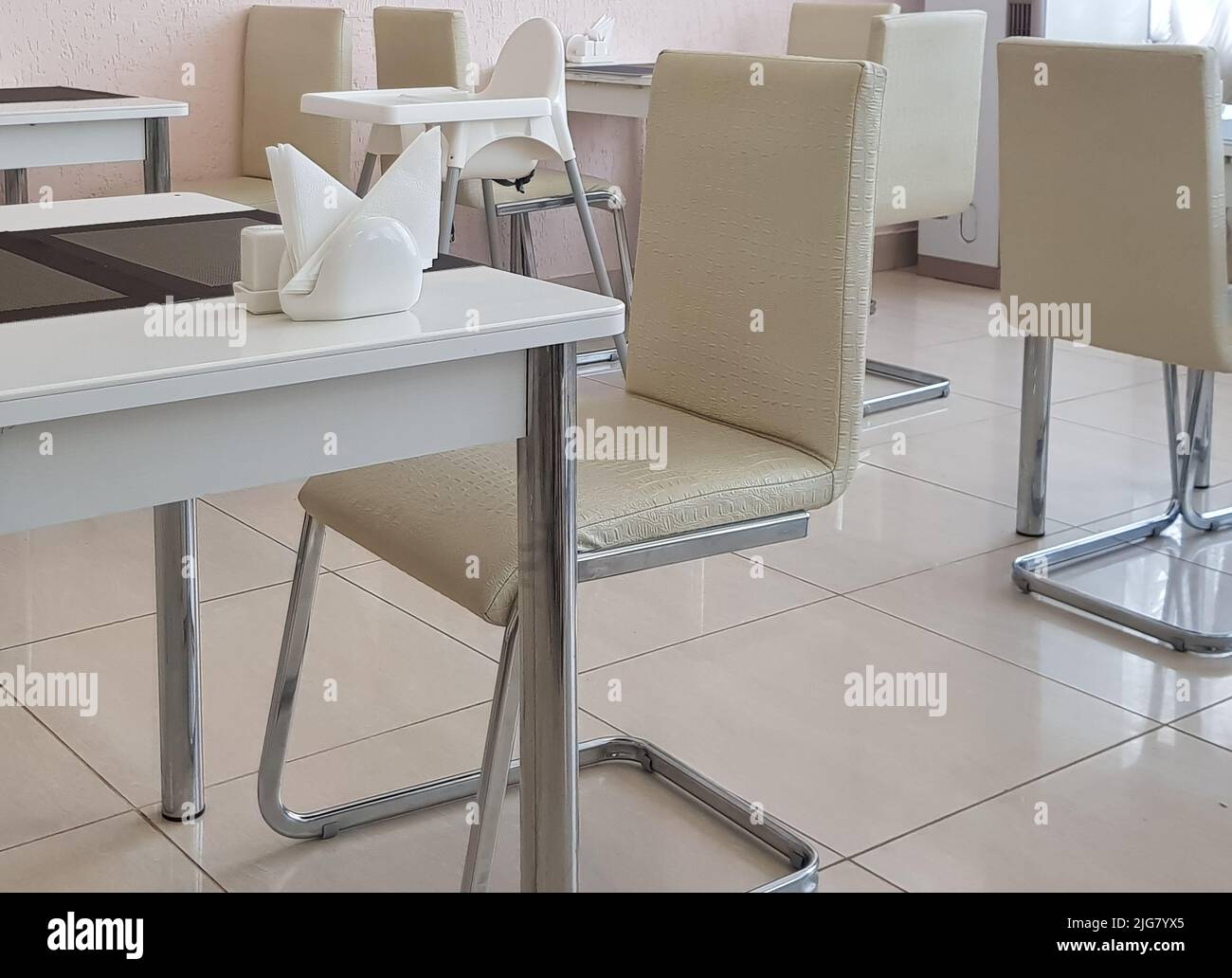 Stylish beige modern dining room interior with designer tables and ...