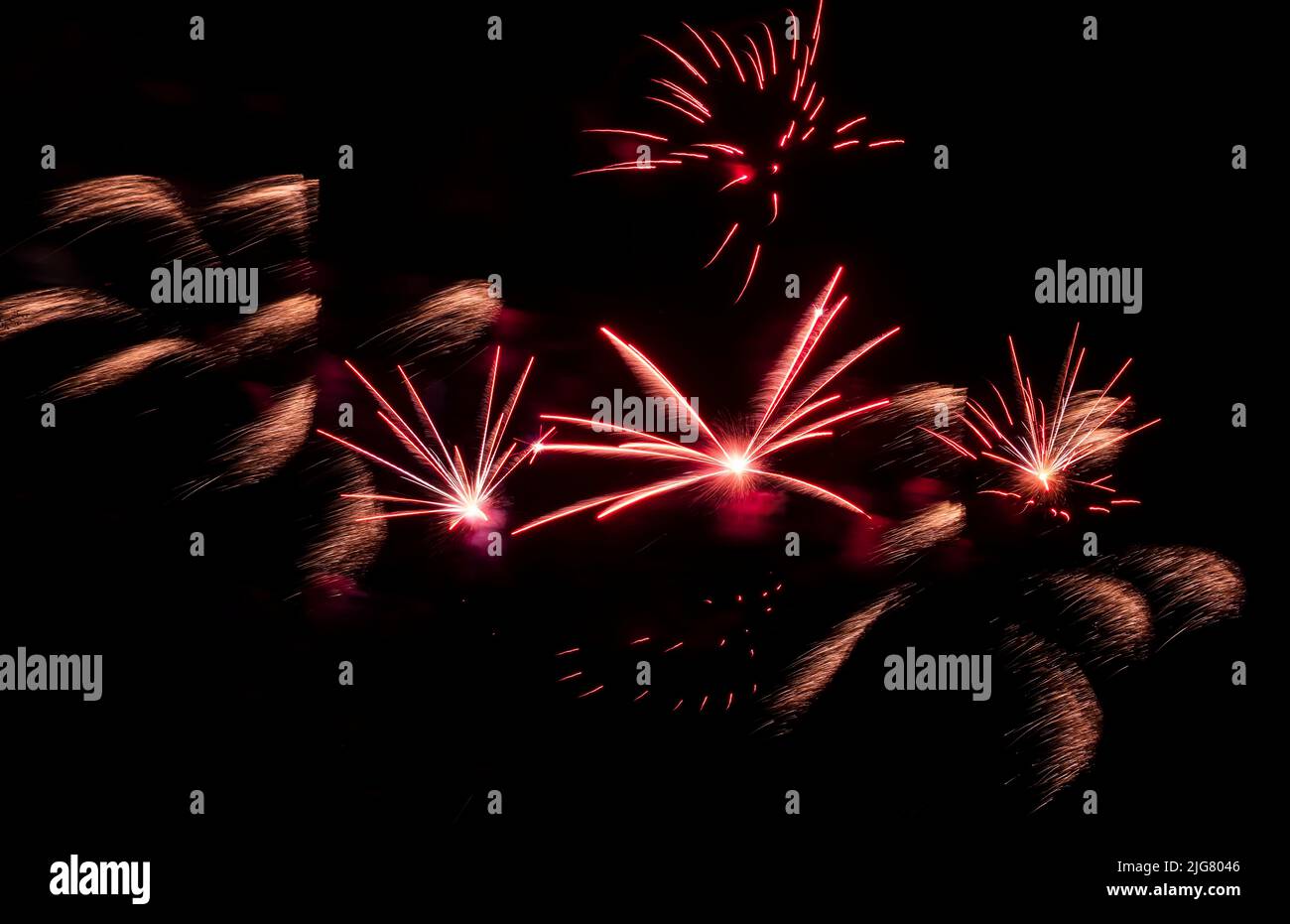 Explosions of pyrotechnics against black night sky. Bright rays of ...