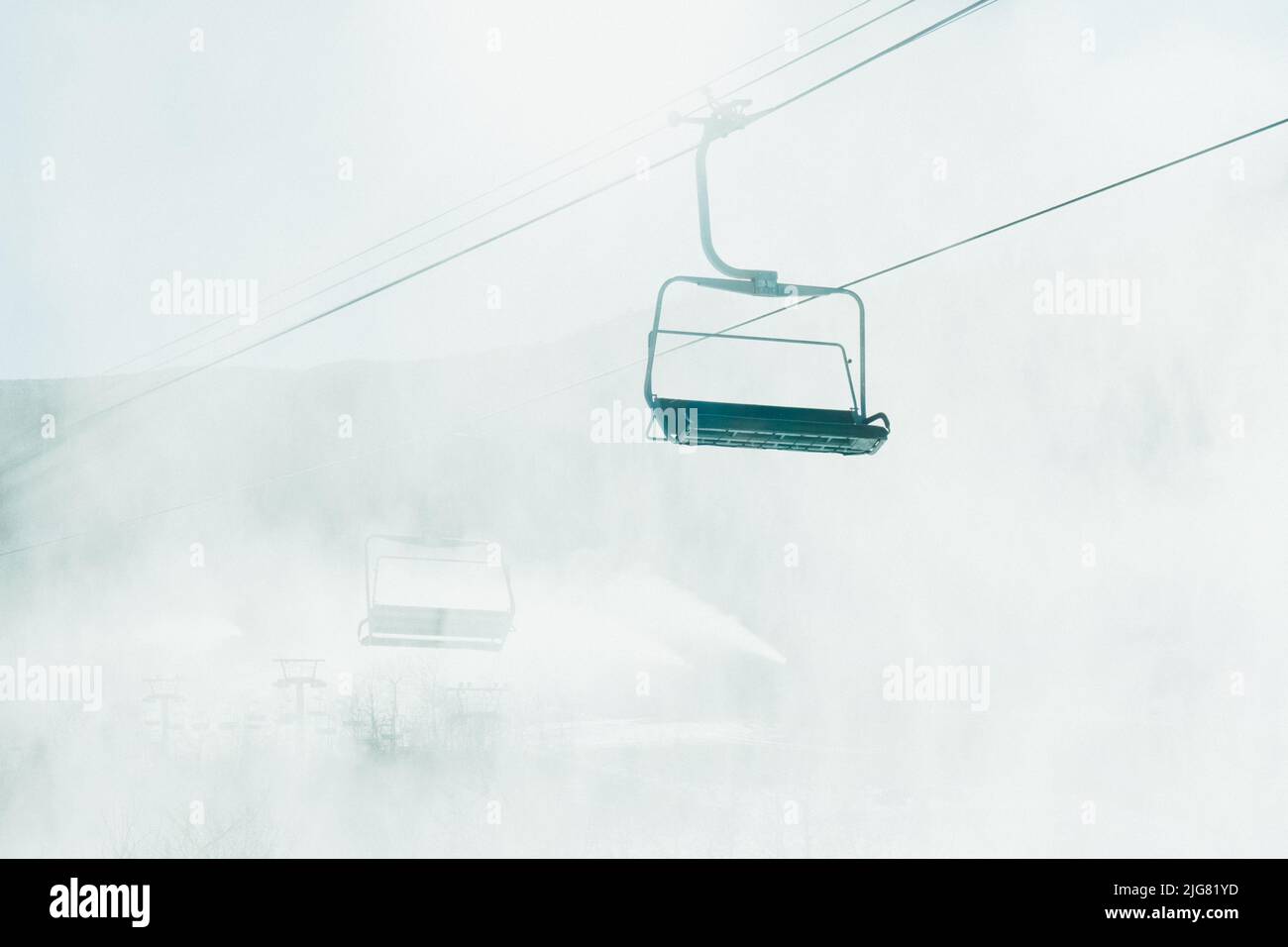 An empty sky lift in an artificial snow cloud Stock Photo - Alamy