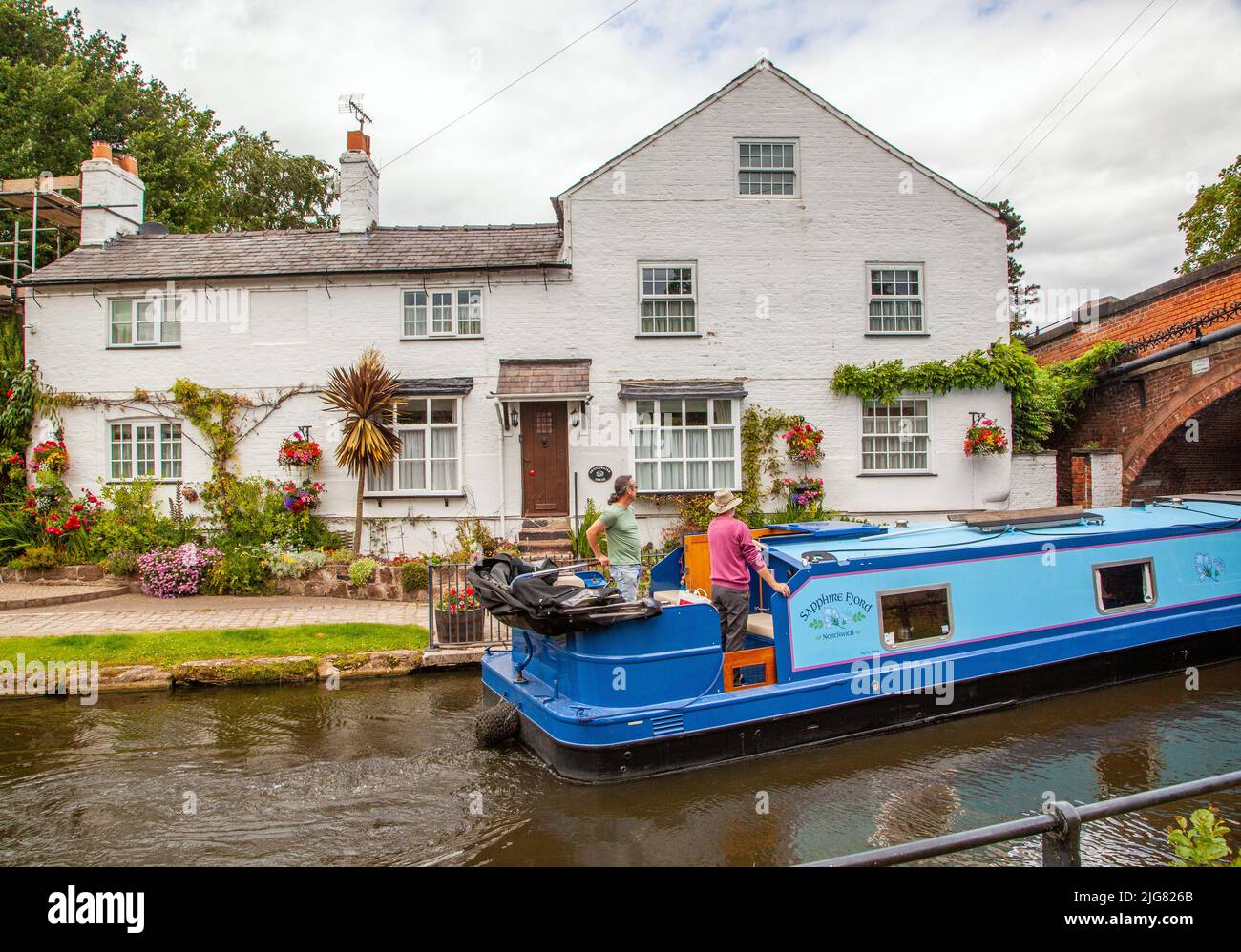 Canal narrowboat passing through the Cheshire village of Lymm on the ...